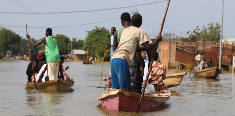 Residentes se desplazan en botes por las inundadas calles de la pequeña ...